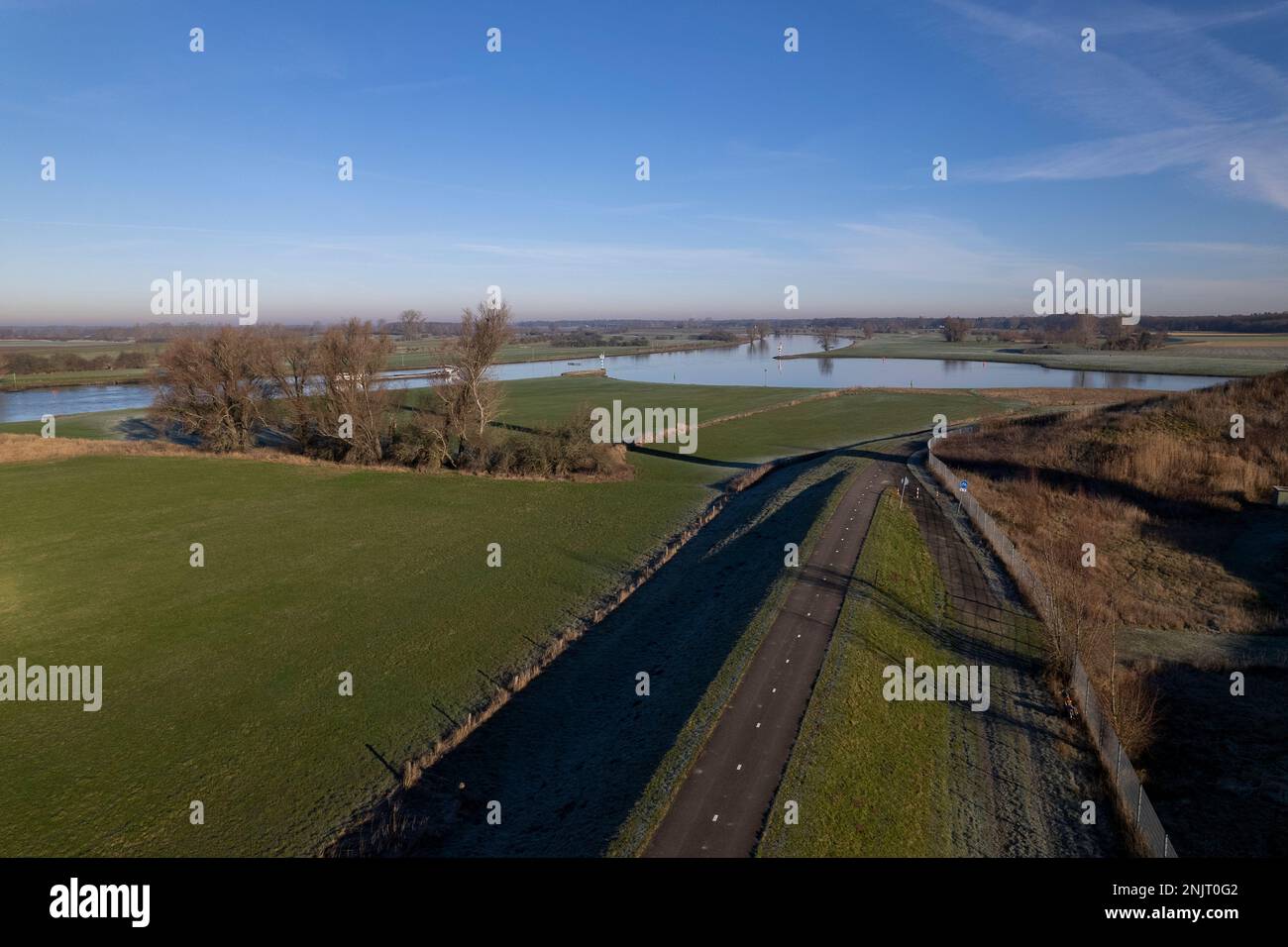 Dutch flat landscape with floodplains and wetlands against a blue sky ...