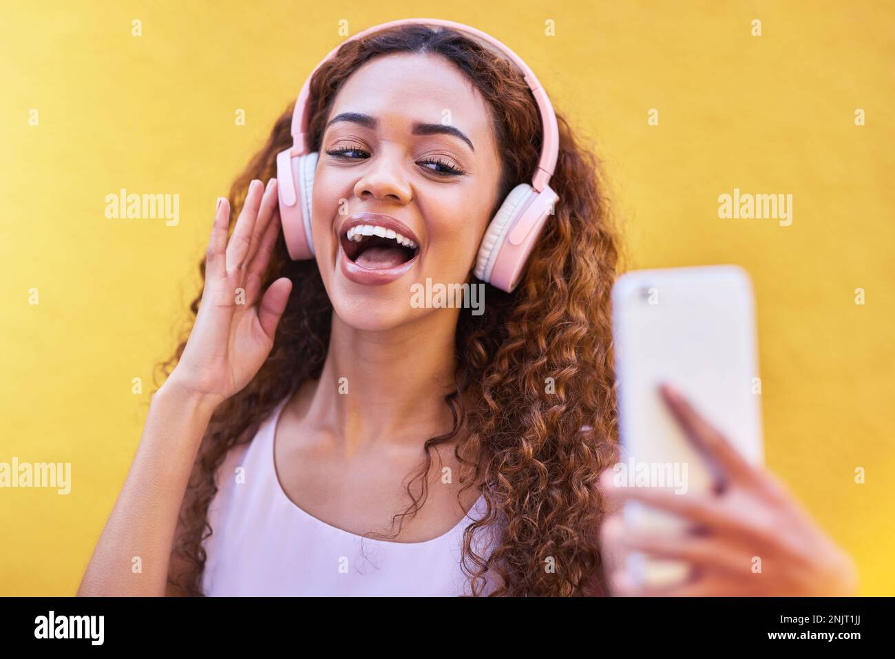 Black woman, music headphones and selfie on yellow wall background for ...