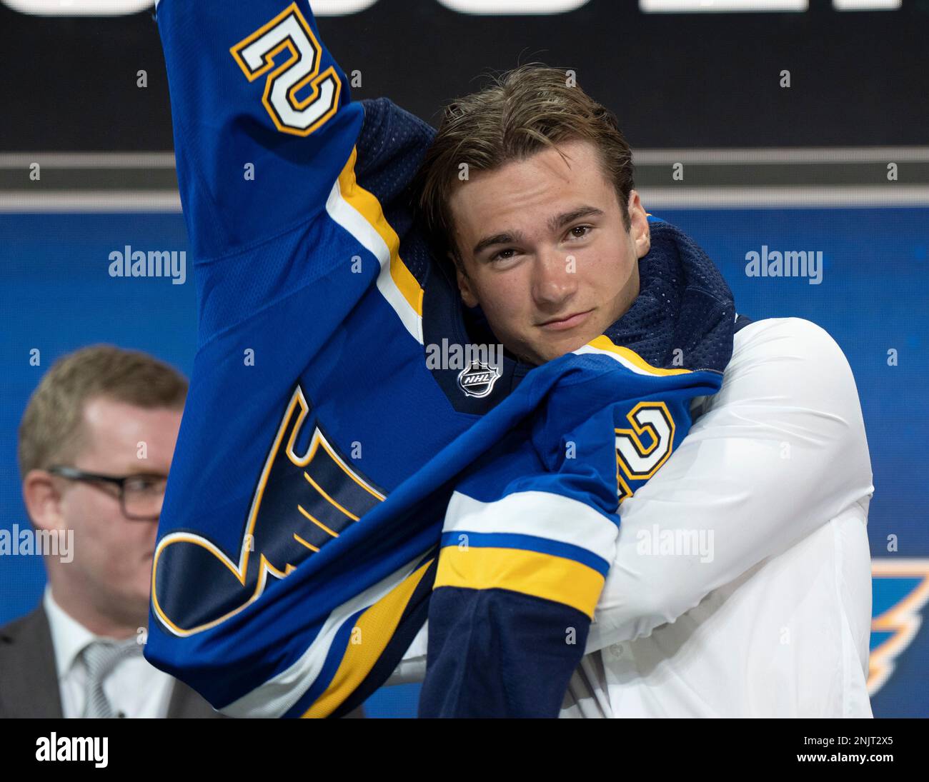 The St. Louis Blues' 23rd pick, Jimmy Snuggerud, puts on his jersey ...