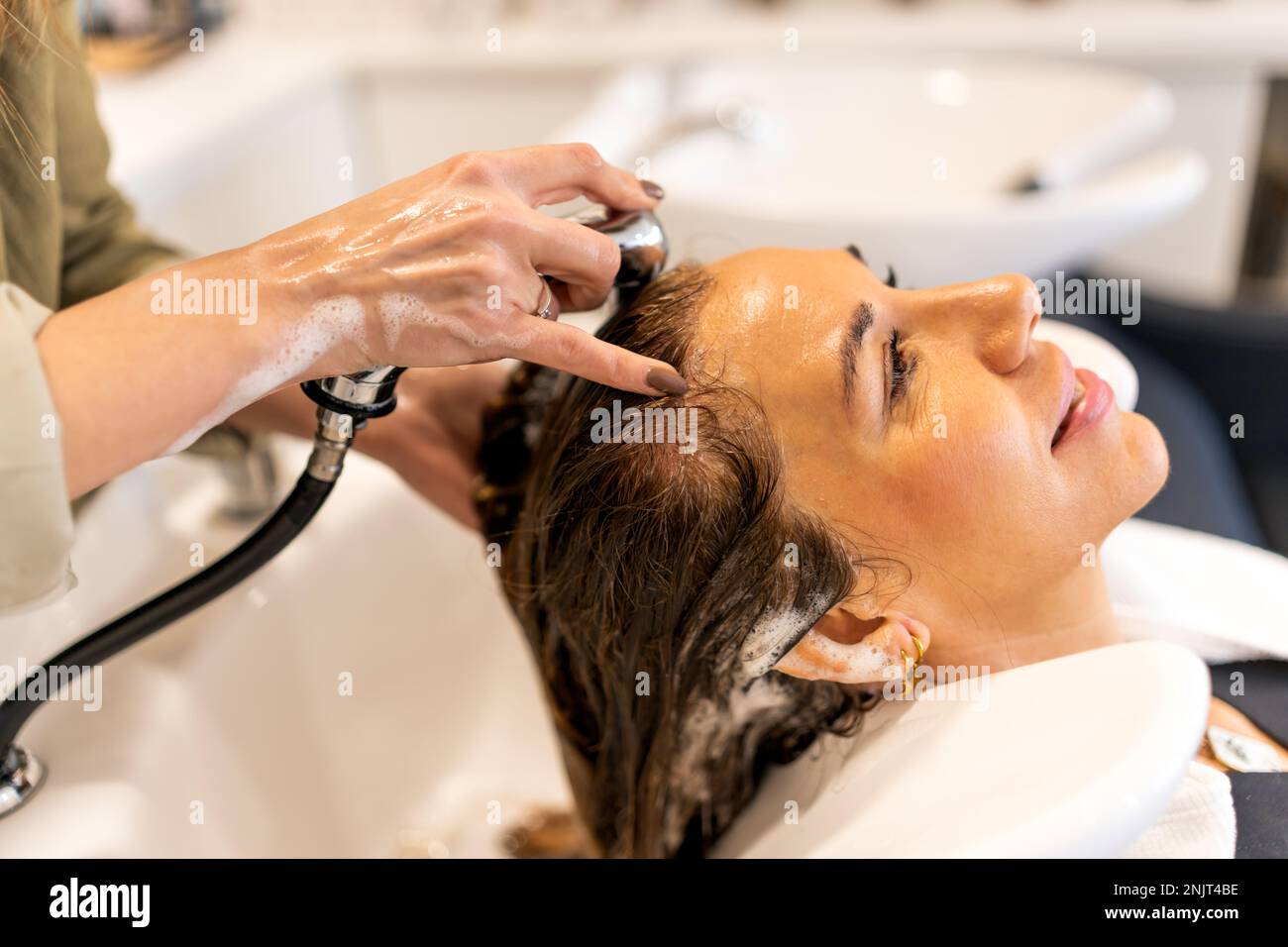 High angle side view of crop anonymous professional hairdresser using ...