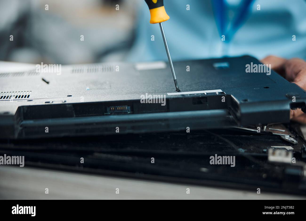 Laptop, technician and fixing with screwdriver, technology maintenance ...