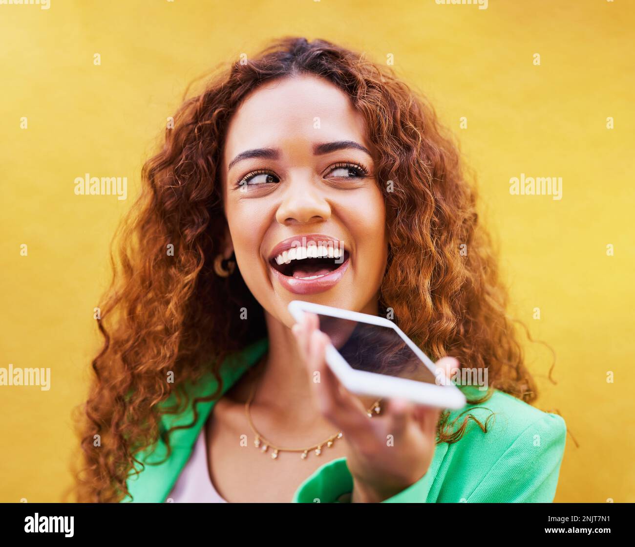Phone, loudspeaker and woman talking on yellow background, color wall ...