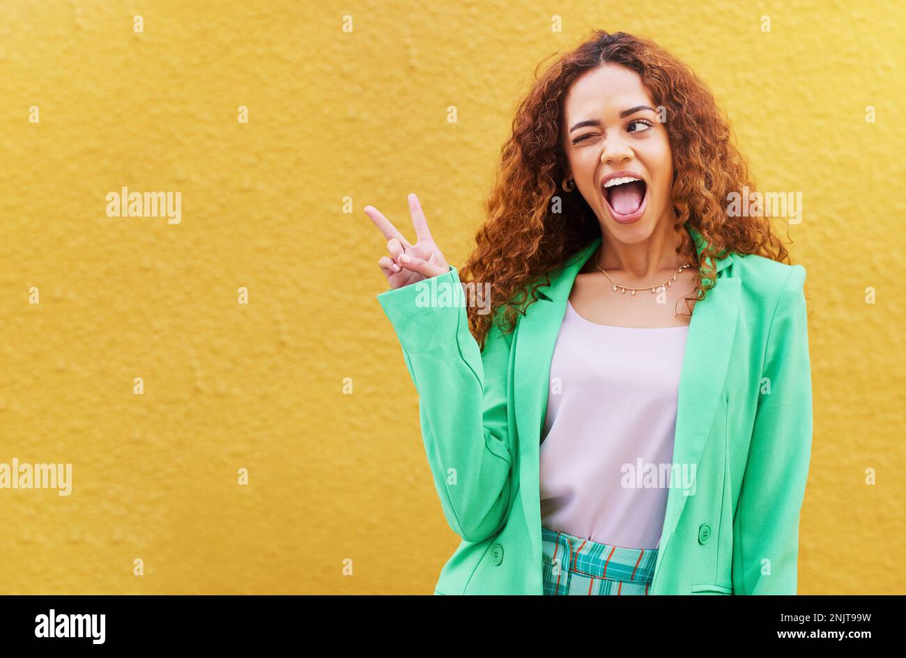 Woman, peace and wink on yellow background, color backdrop and mockup ...