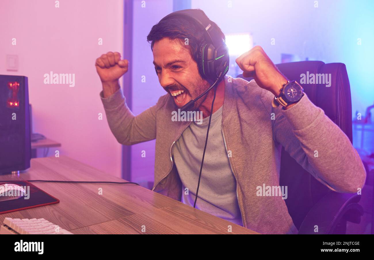 Winner, achievement or man gamer on computer with microphone ...