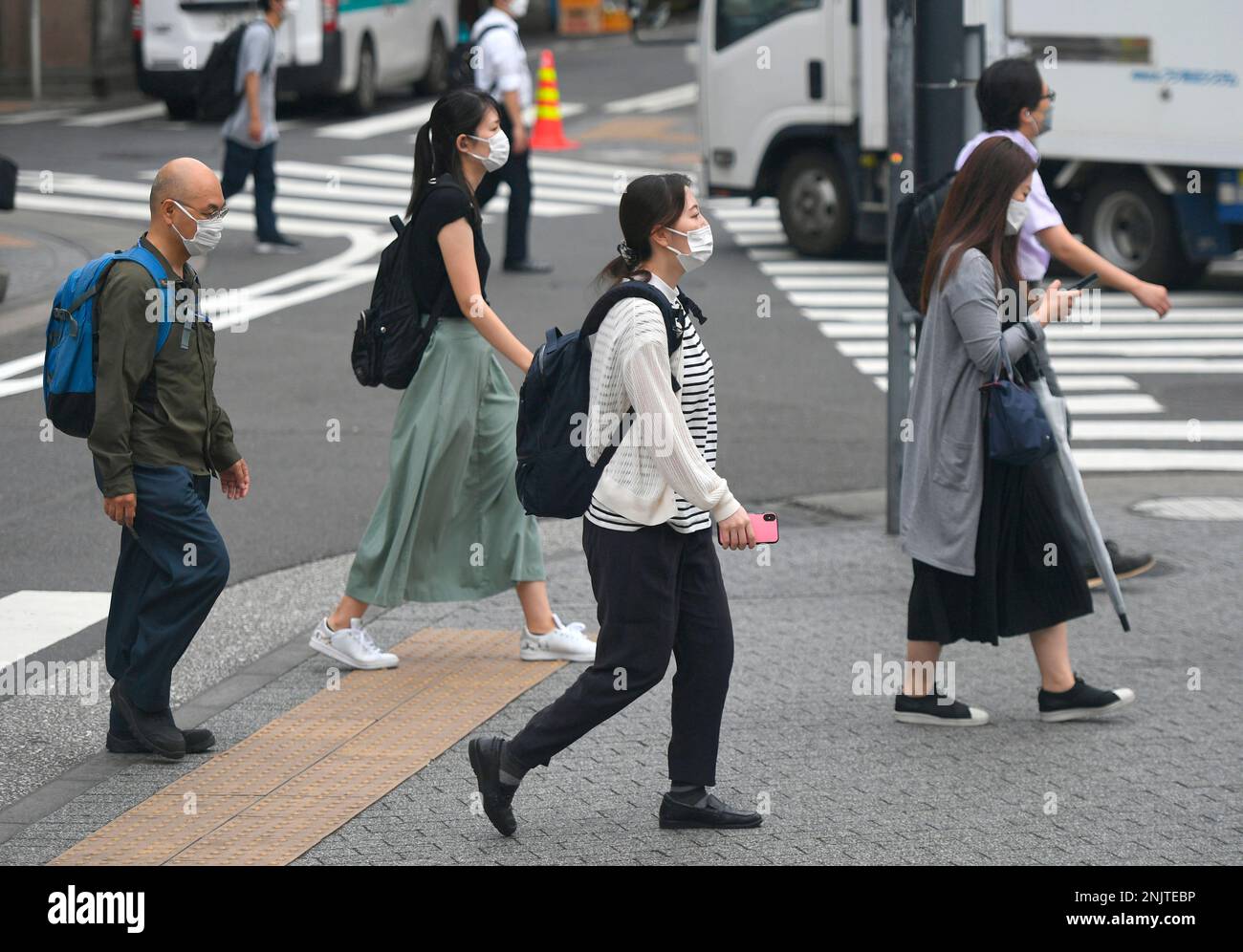 People wearing face masks are seen during commuting hour in Minato Ward ...