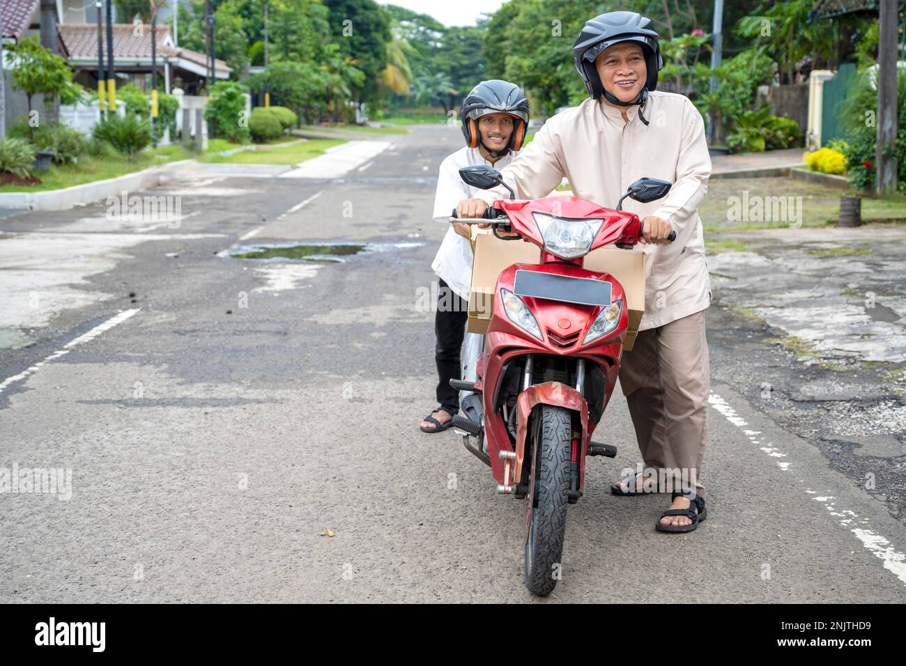 Asian Muslim family pushing a motorcycle when going mudik to hometown ...