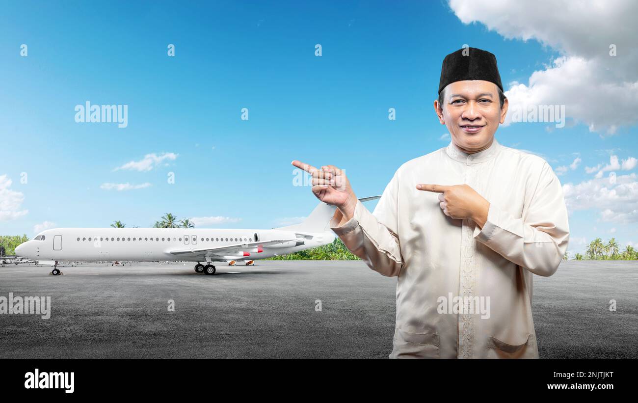 Asian Muslim man pointing to the airplane for mudik with a blue sky ...