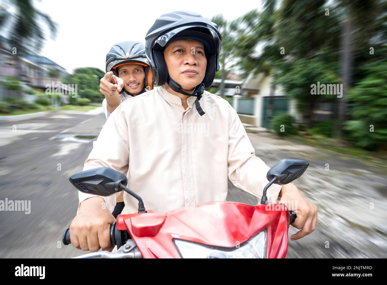 Asian Muslim family carrying a box on a motorcycle going mudik to ...