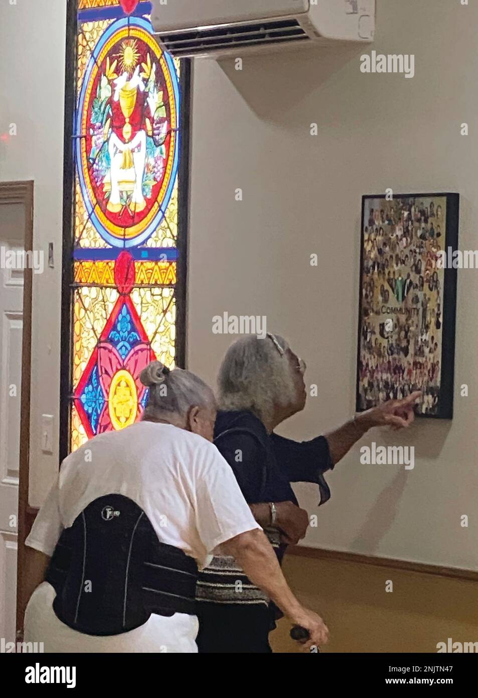 Two African-American ladies look at the community pictures inside St ...