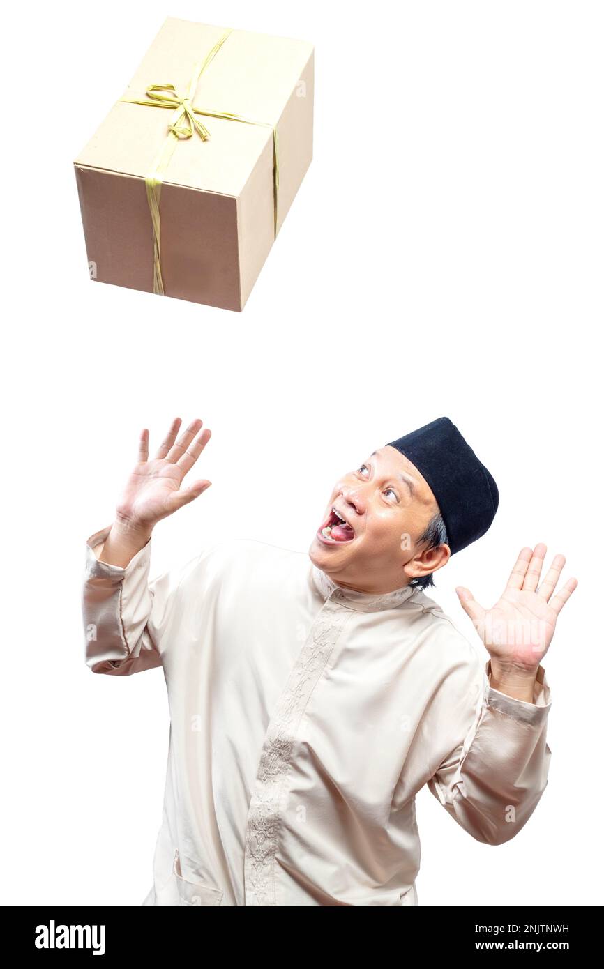 Asian Muslim man afraid of dropping box isolated over white background ...