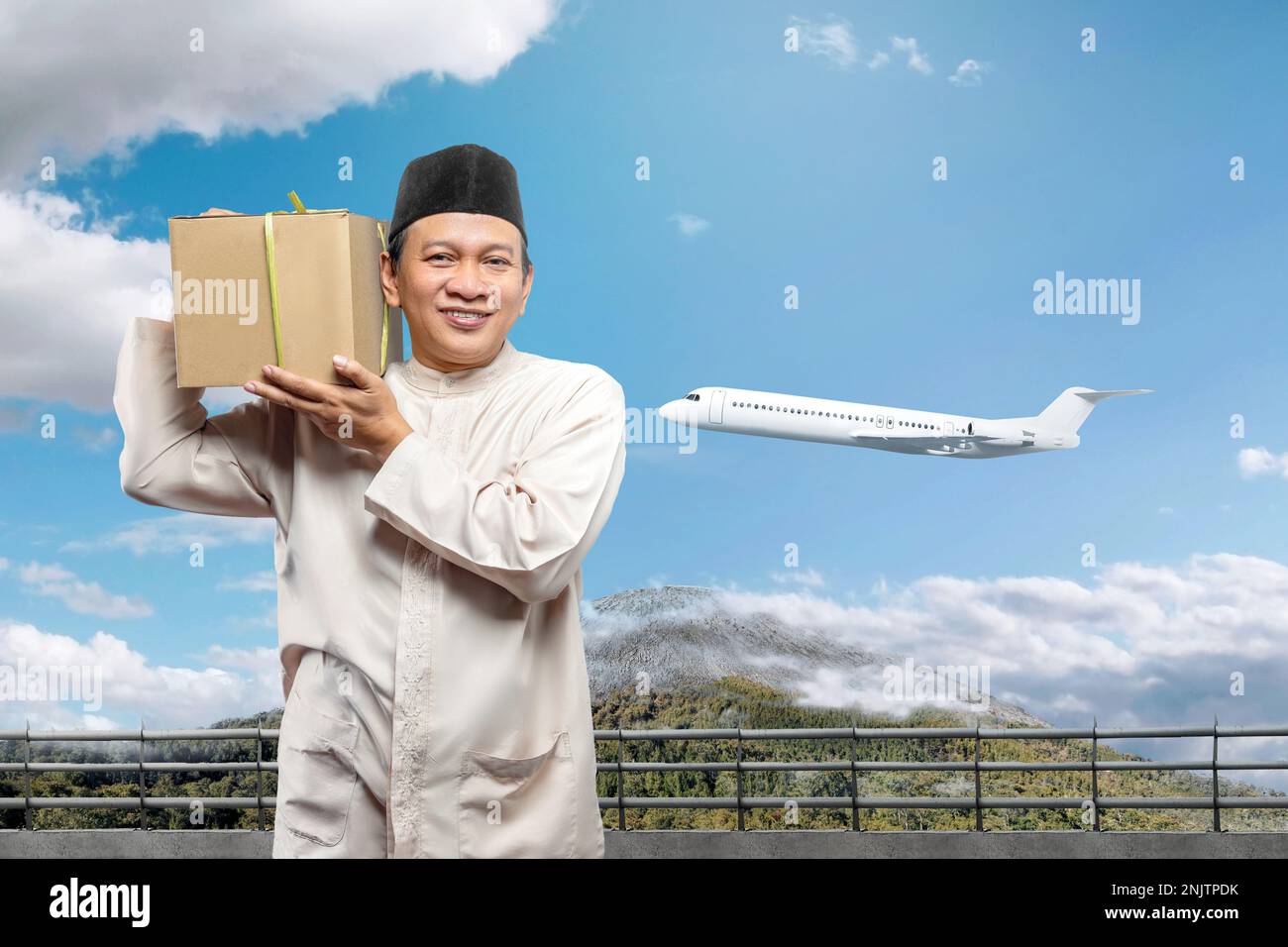 Asian Muslim man carrying box ready to mudik with flying airplane ...