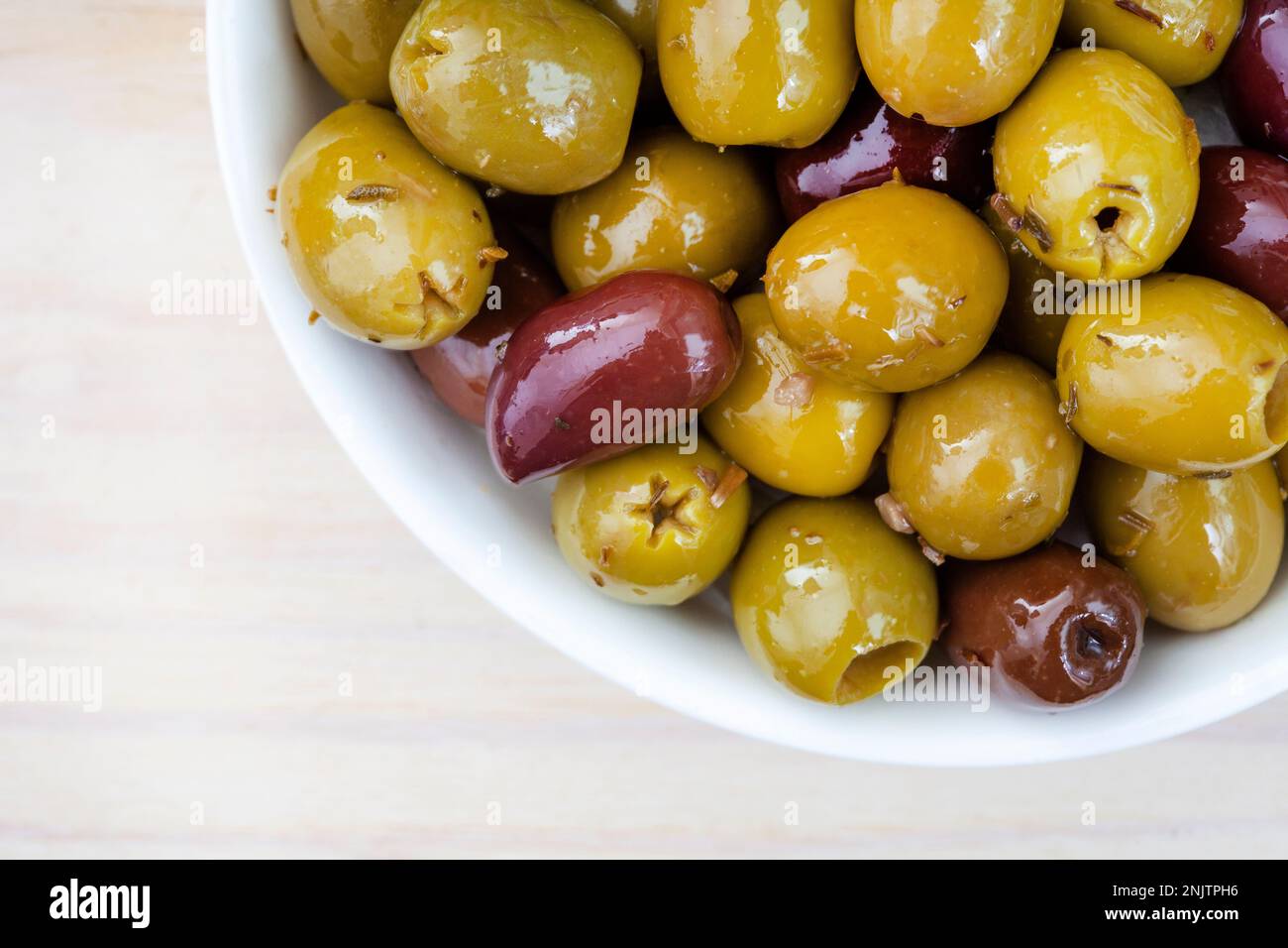 Mixed marinated olives on light wooden surface with copy space Stock ...