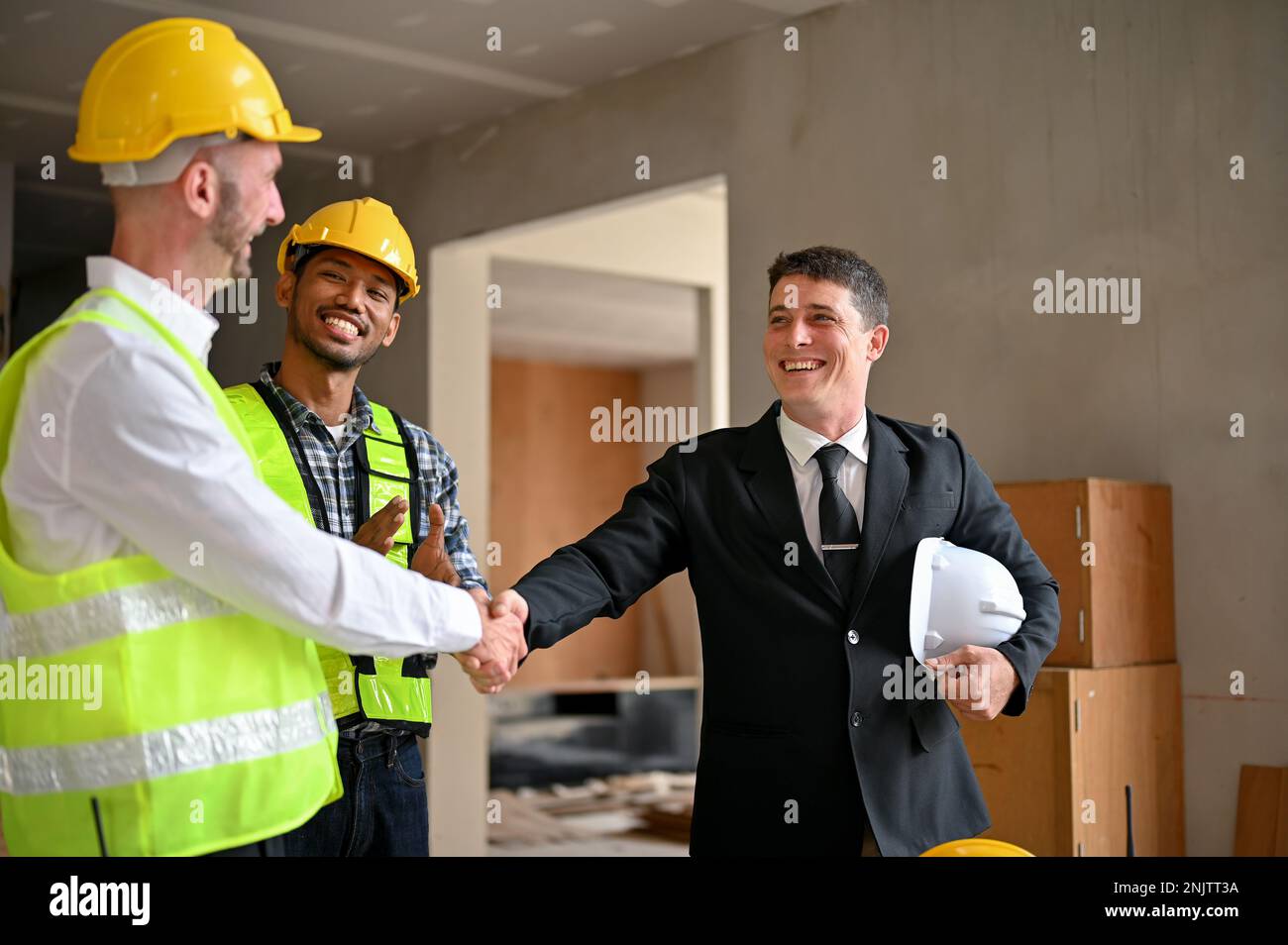 Cheerful Caucasian businessman in formal business suit is shaking hands ...