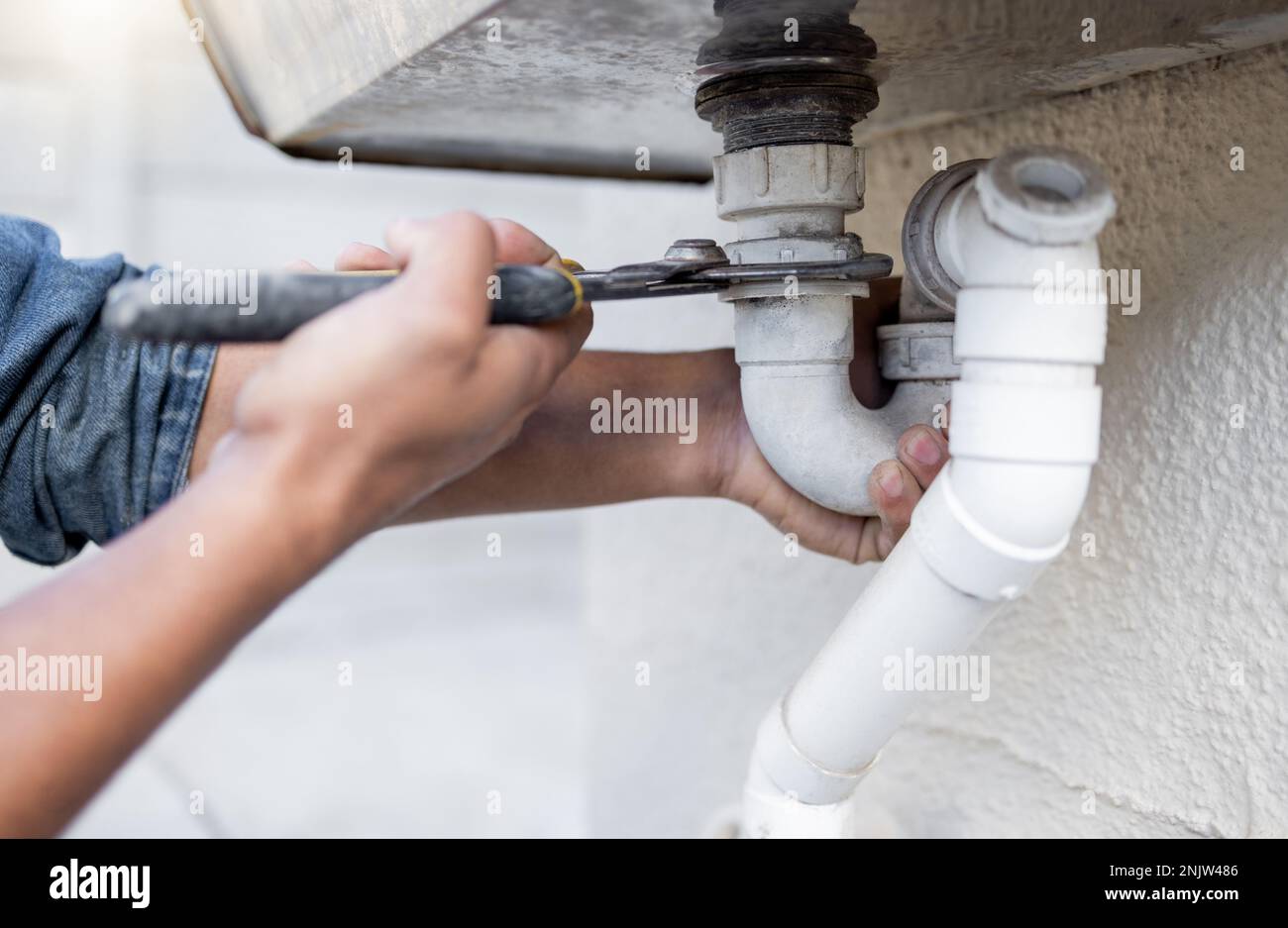 Hands, tool and pipe with a man plumber fixing a water system as a DIY ...