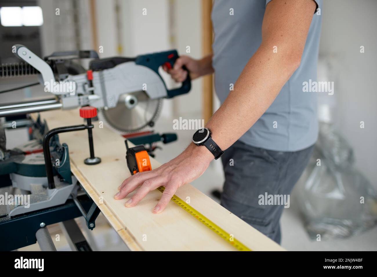 Middle aged man with grey hair and grey shirt laying parquet floor in ...