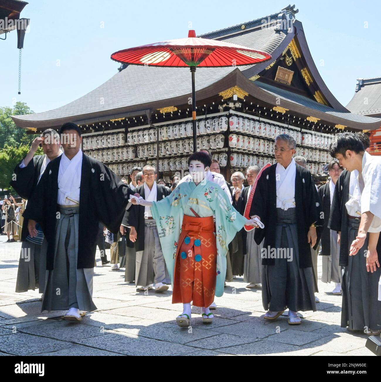 A boy whose face is make-up in white powder visits Yasaka Shrine with worshippers during the ...