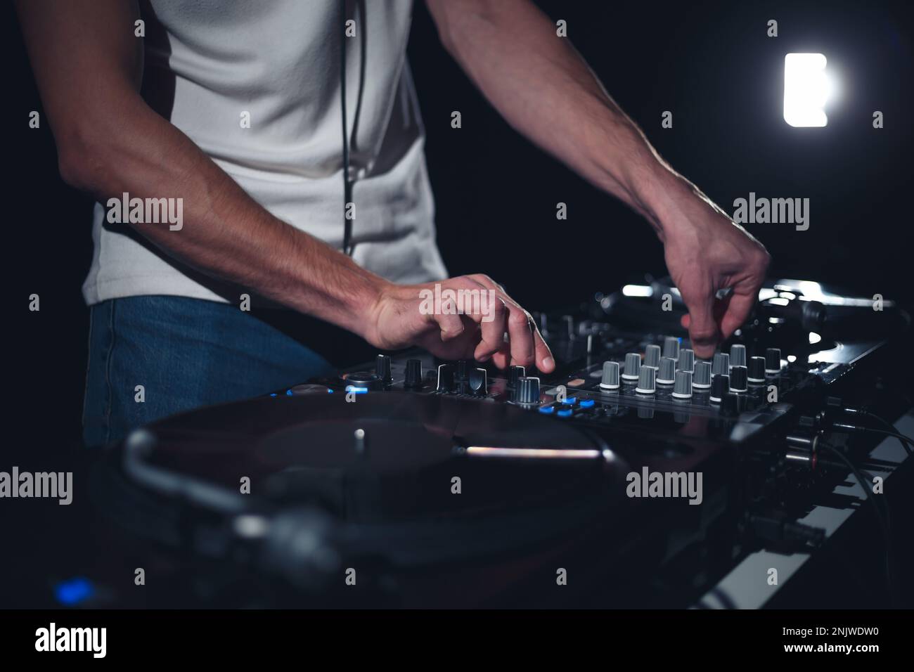 Concert DJ playing music on stage. Nightclub disc jockey mixing music ...