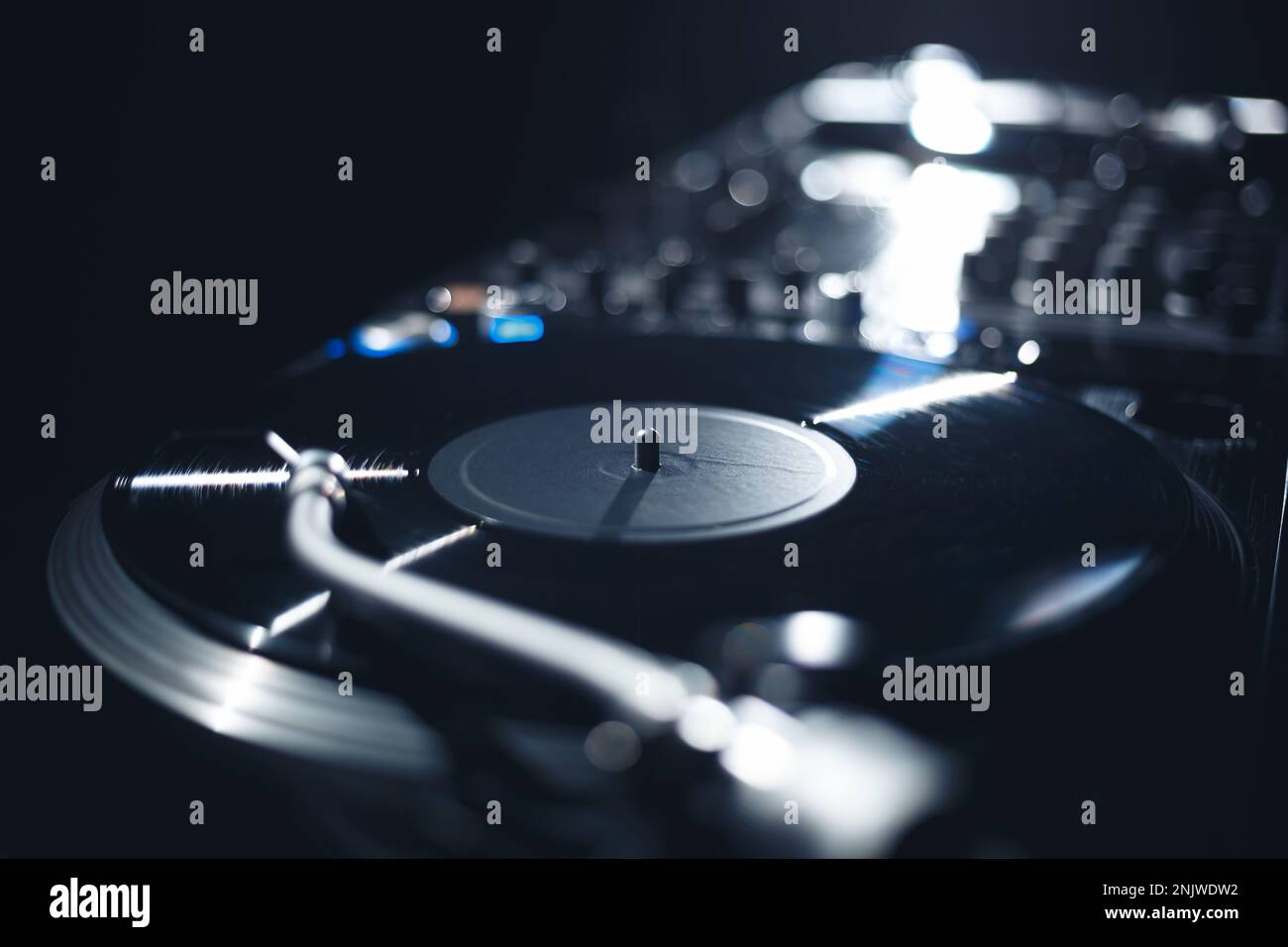 Hip hop DJ turtnables and sound mixer in night club. Plays music set ...