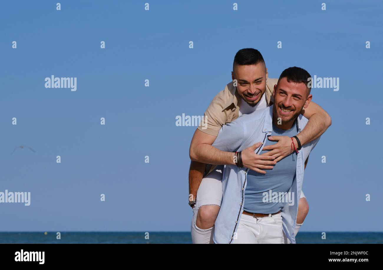 Man carrying his boyfriend on his back outdoors Stock Photo - Alamy