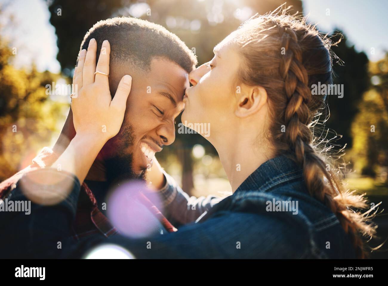 Interracial Couple Forehead Kiss And Smile In Nature For Love Bonding
