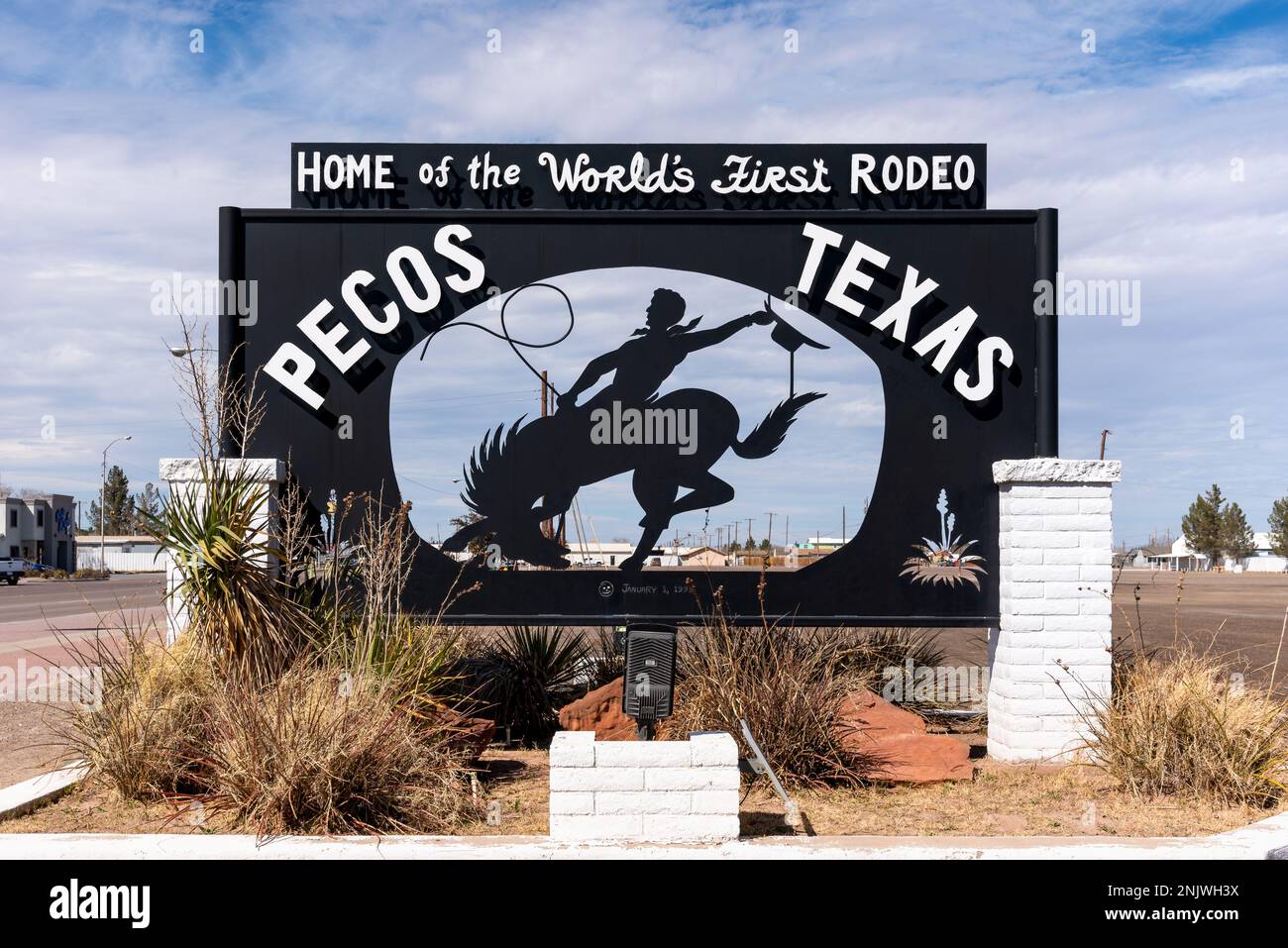A large black roadside sign with the image of a rodeo ride cut out in ...