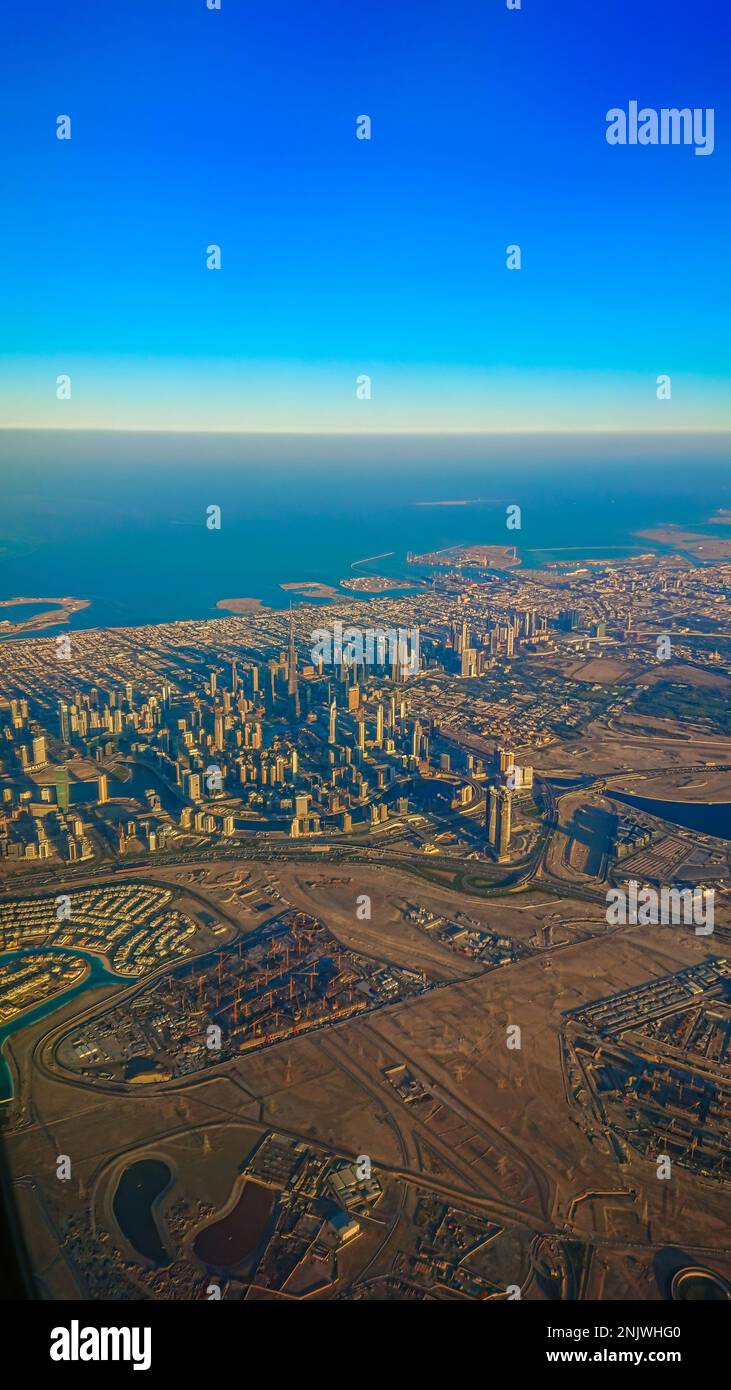 Aerial view of Burj Khalifa from the plane. Blue sky and golden city ...