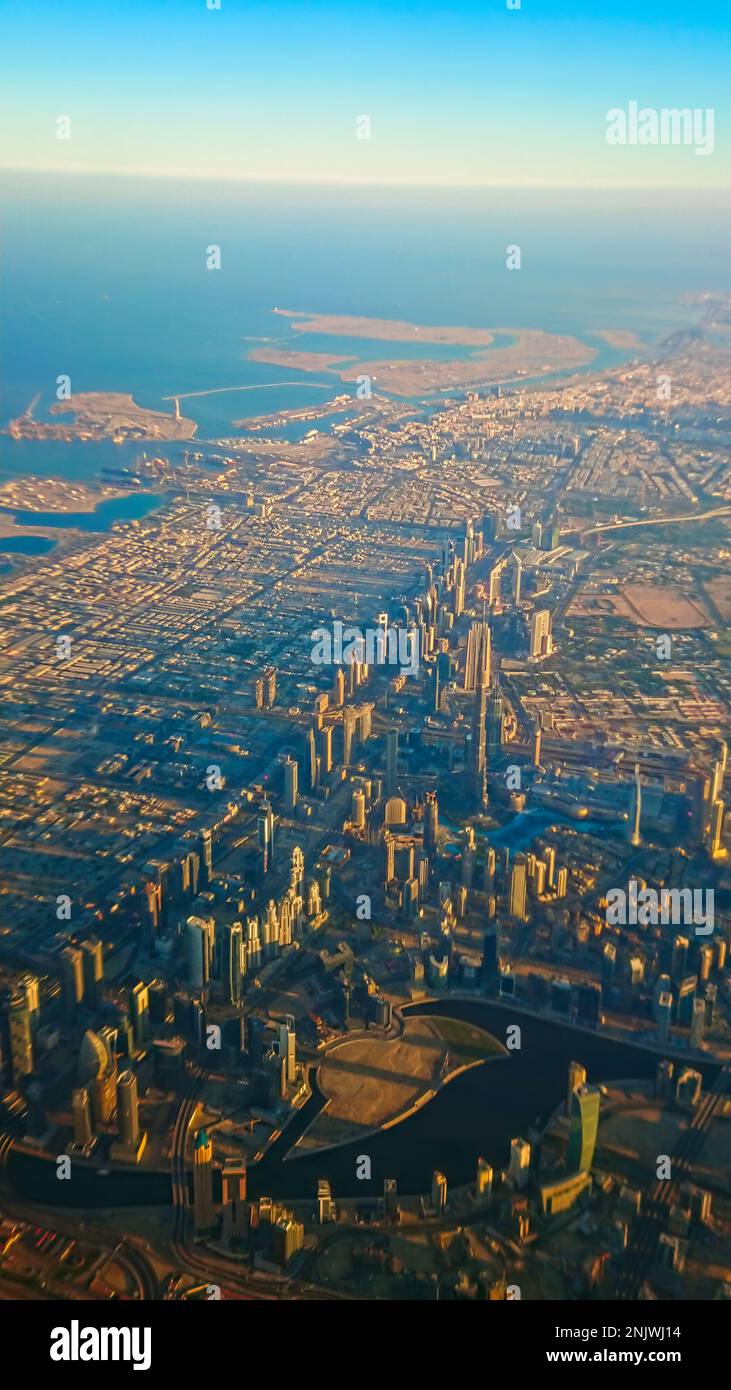 Aerial view of Burj Khalifa from the plane. Blue sky and golden city ...