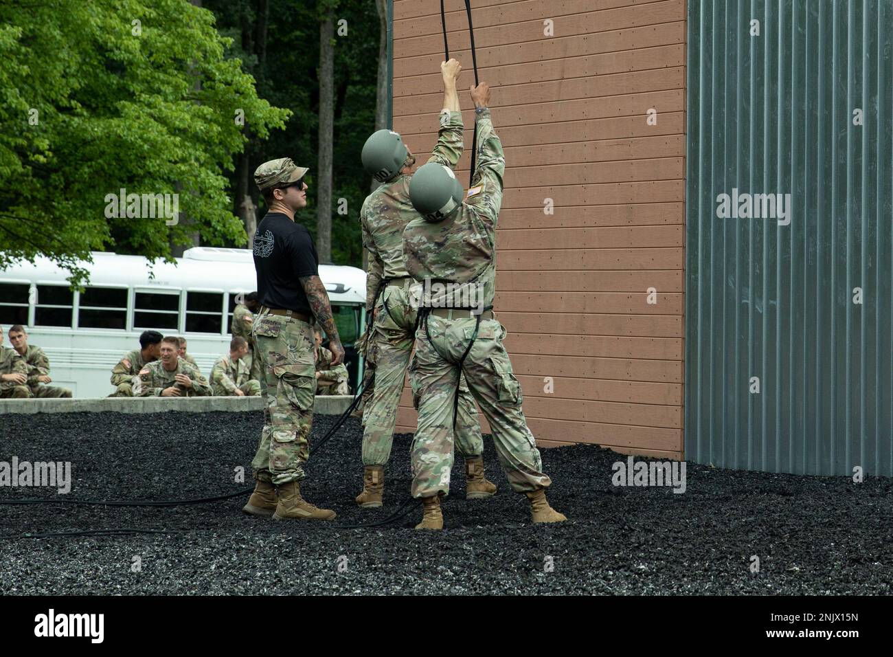 Two Soldiers part of the belay team secure the rappel ropes at base of ...