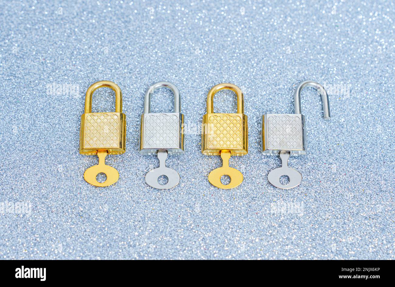 Row of four shiny metal padlocks with master keys on a sparkling ...