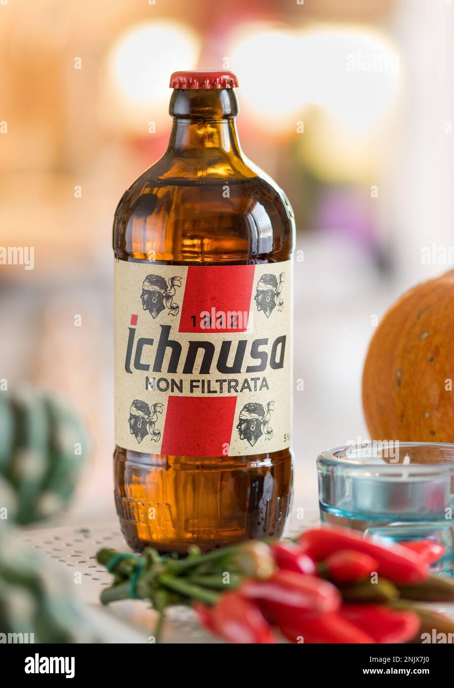 Glass brown unfiltered Ichnusa Italian beer bottle with beige and red ...