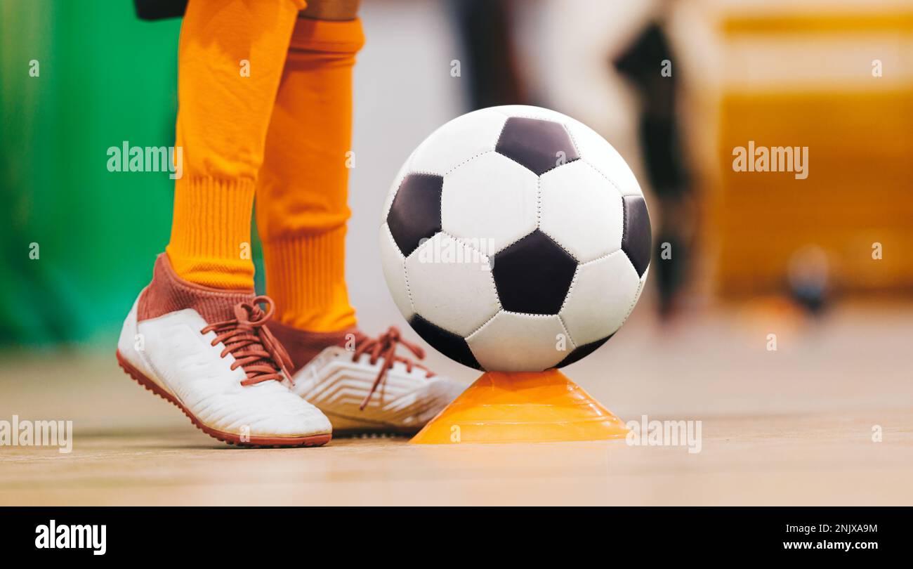 School boy on indoor soccer football training. Soccer ball and orange ...
