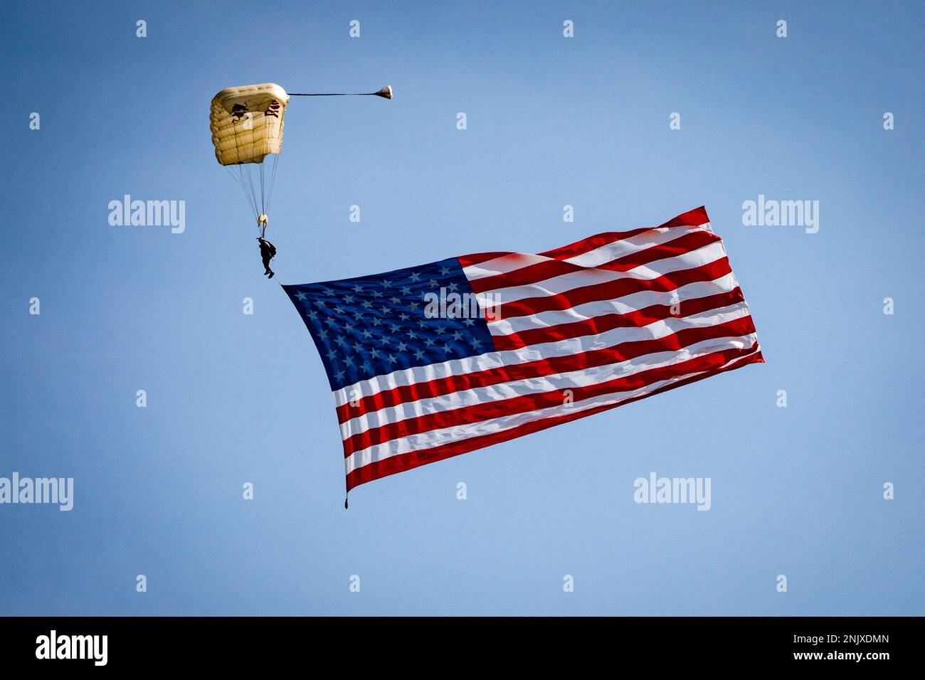 An American flag is proudly positioned atop an open American parachute ...