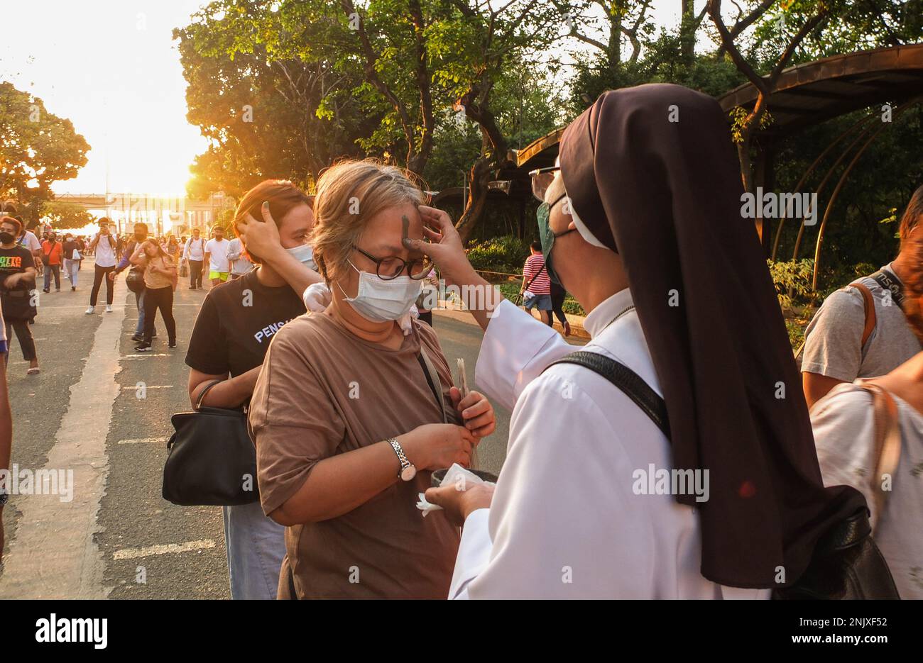 A nun applies ash on the forehead of a woman at Baclaran church ...