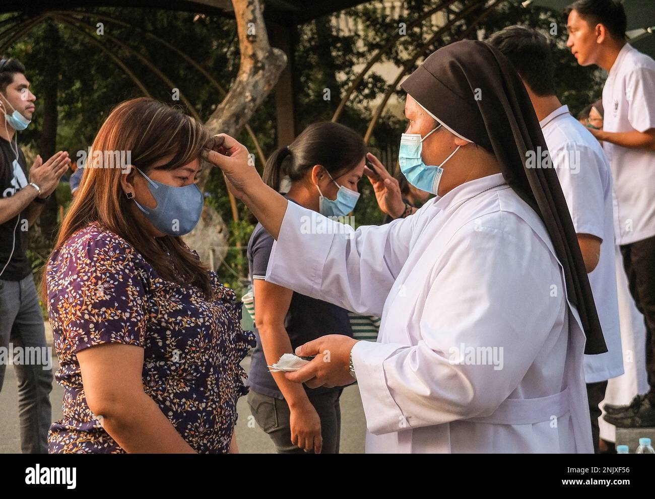 A nun applies ash on the forehead of a woman at Baclaran church ...