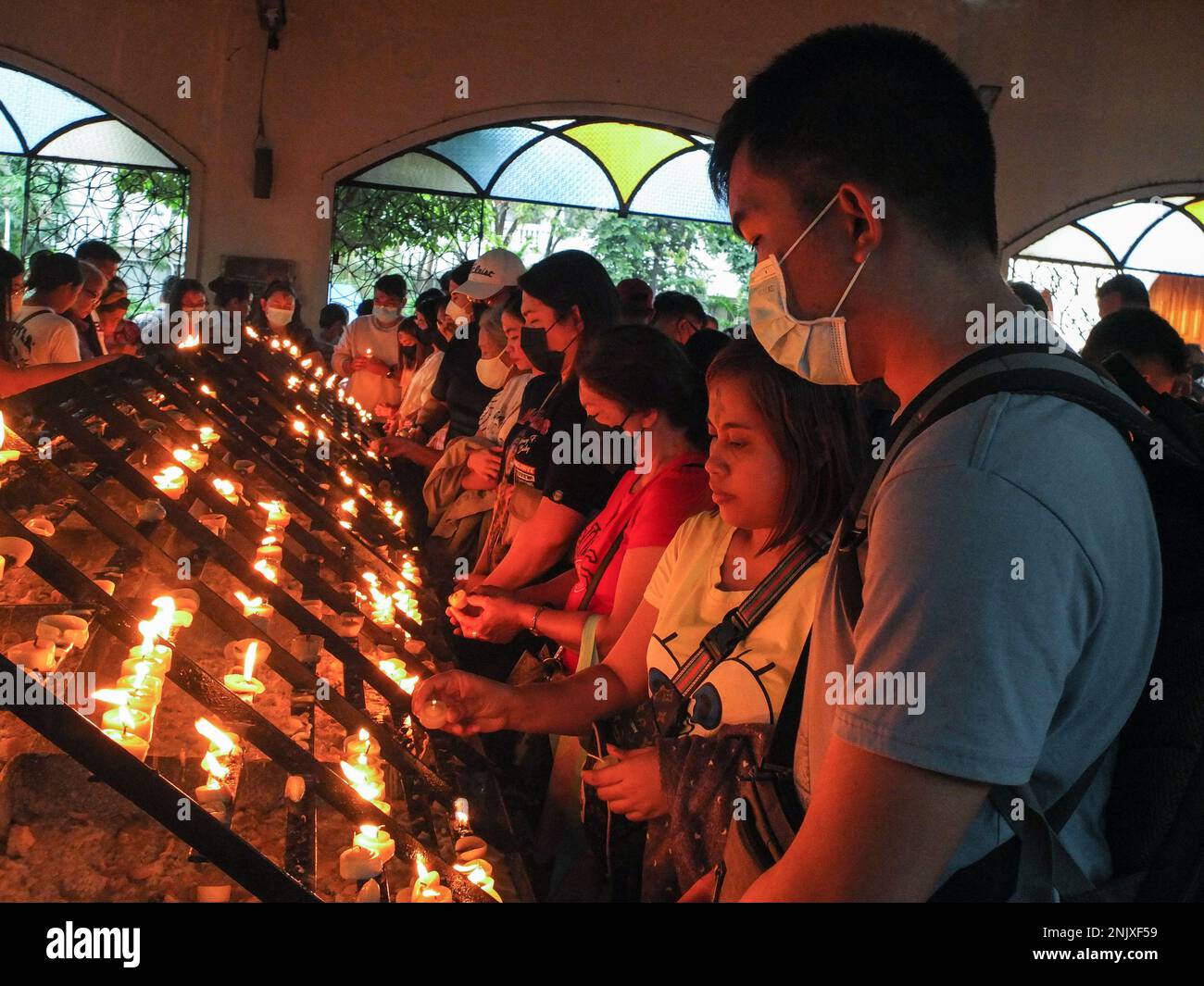 Catholic devotees light candles at the candle chapel of the Baclaran ...