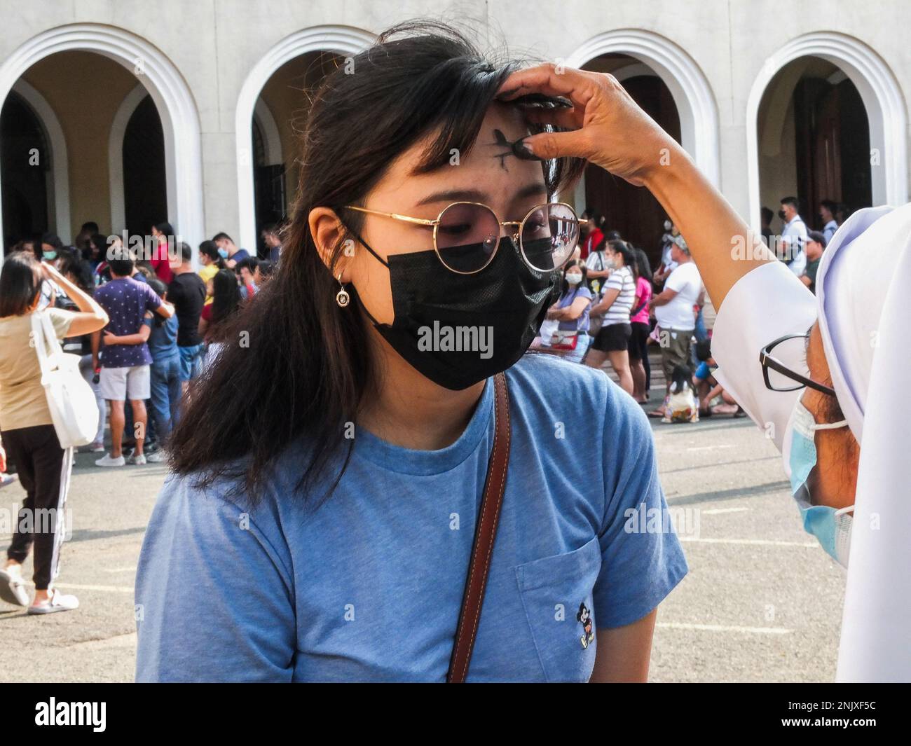 A female devotee receives ash marking on her forehead. Catholic ...