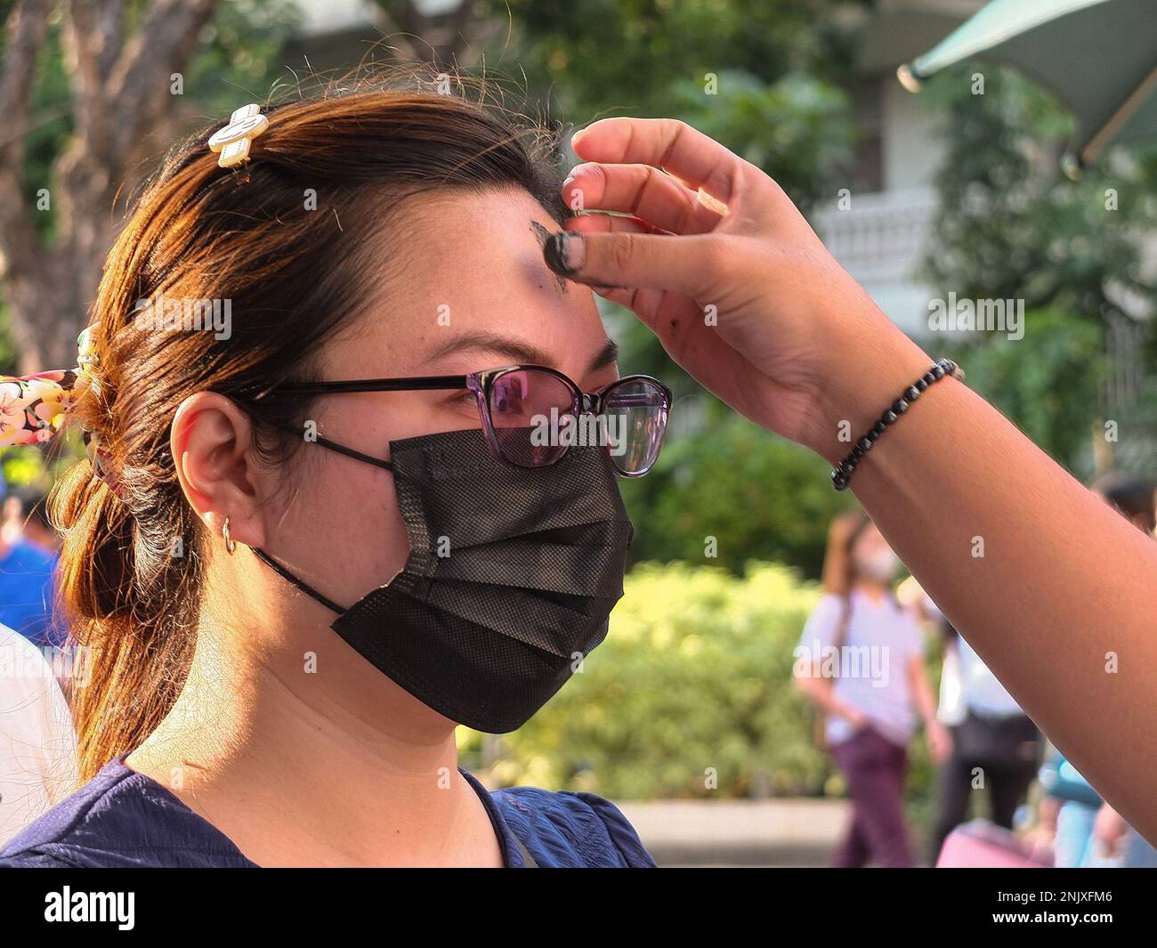 A female devotee receives ash marking on her forehead. Catholic ...