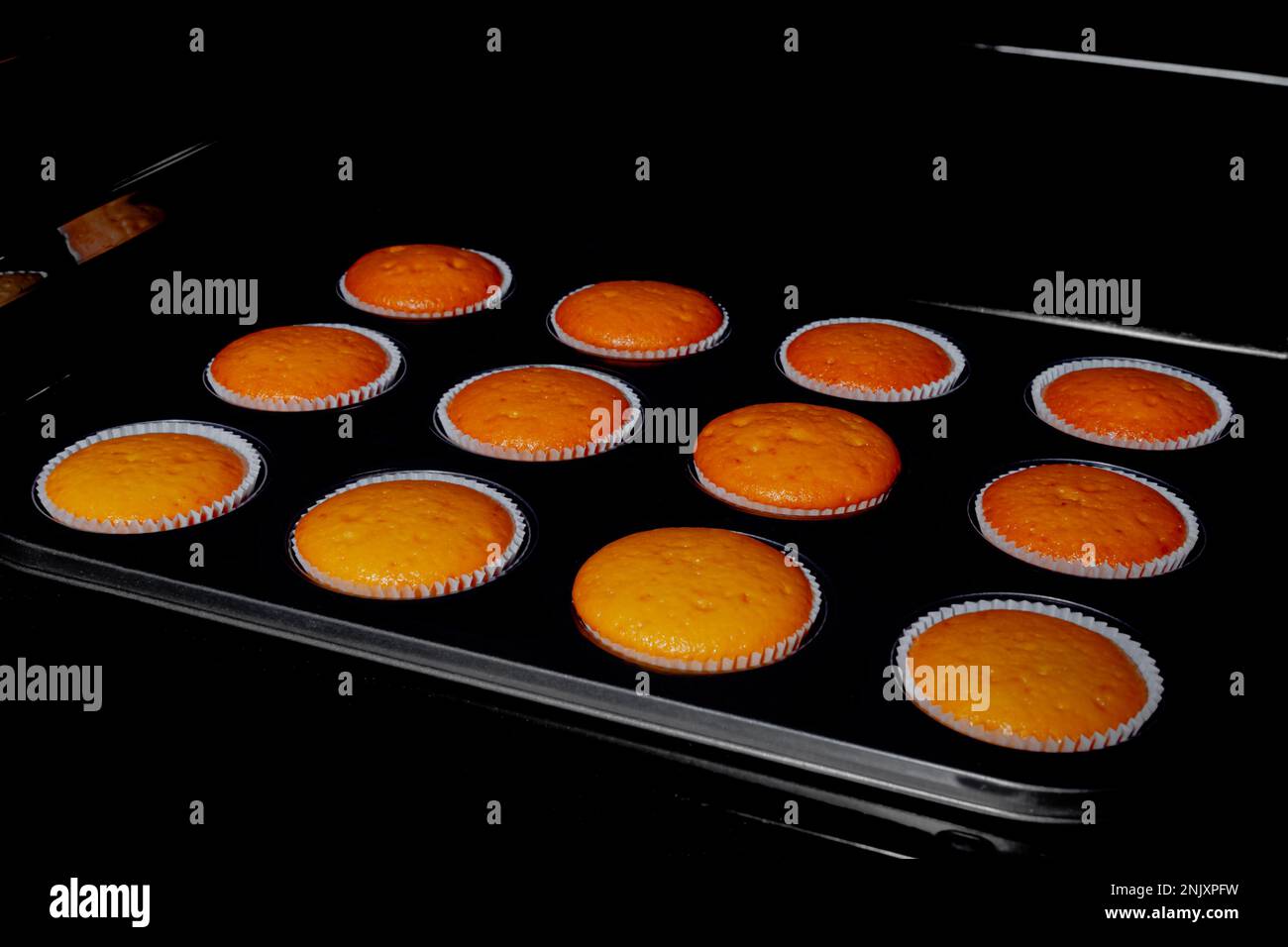 Twelve baked cupcakes, muffins in electric oven Stock Photo - Alamy