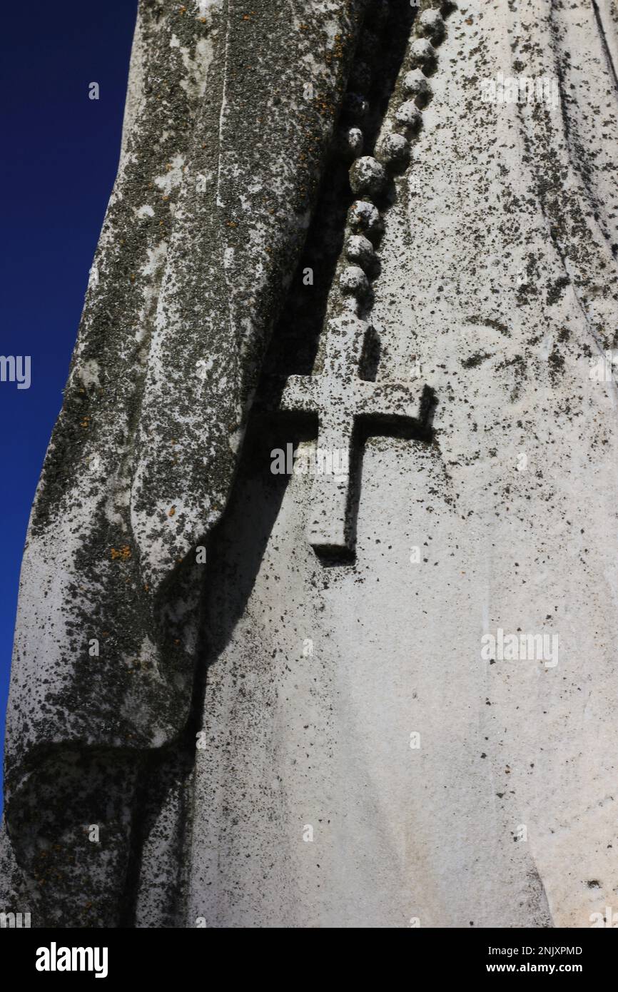 A Christian cross hanging on a statue and carved in natural stone Stock ...