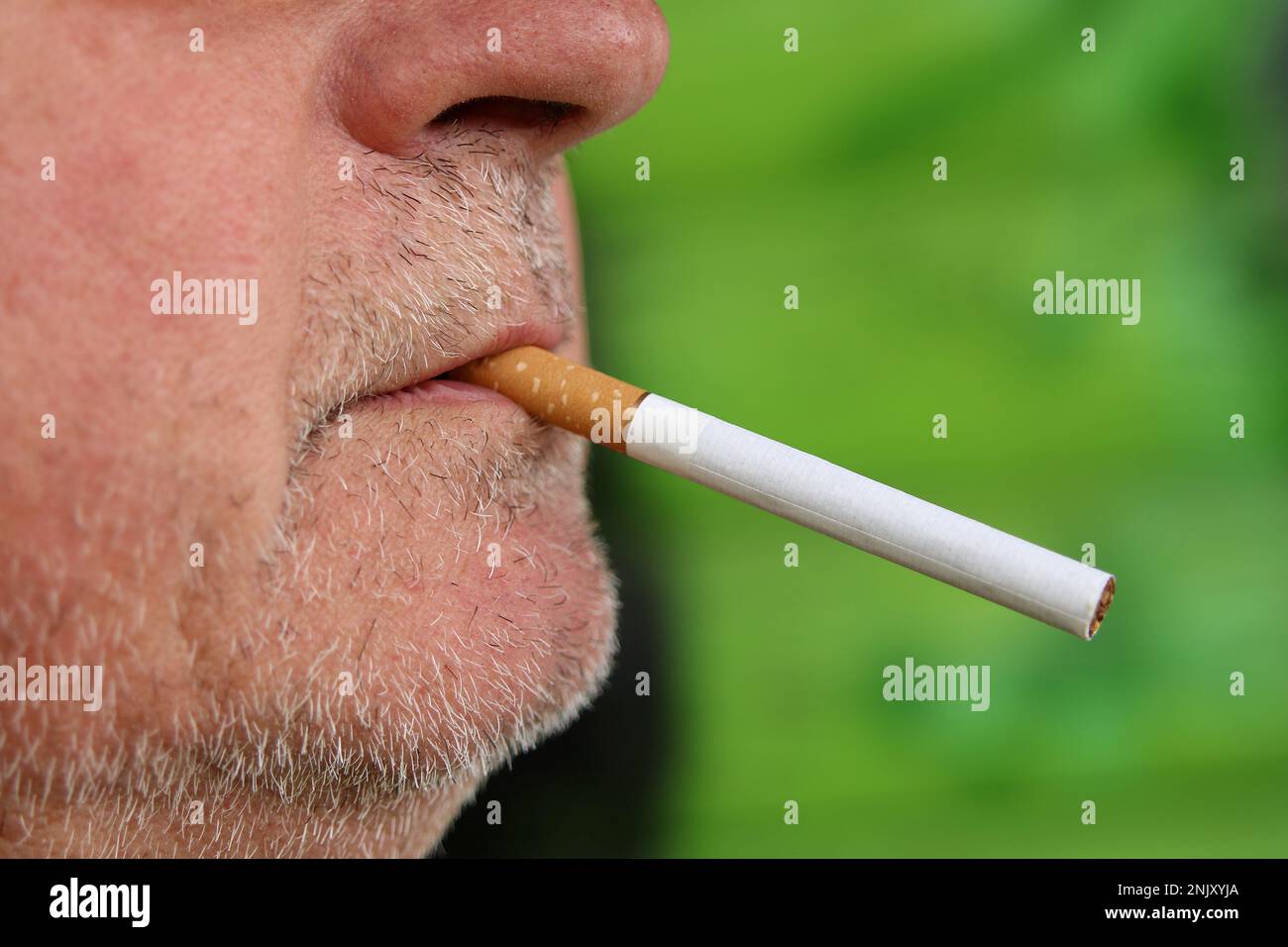 man with a cigarette in his mouth, side view Stock Photo - Alamy