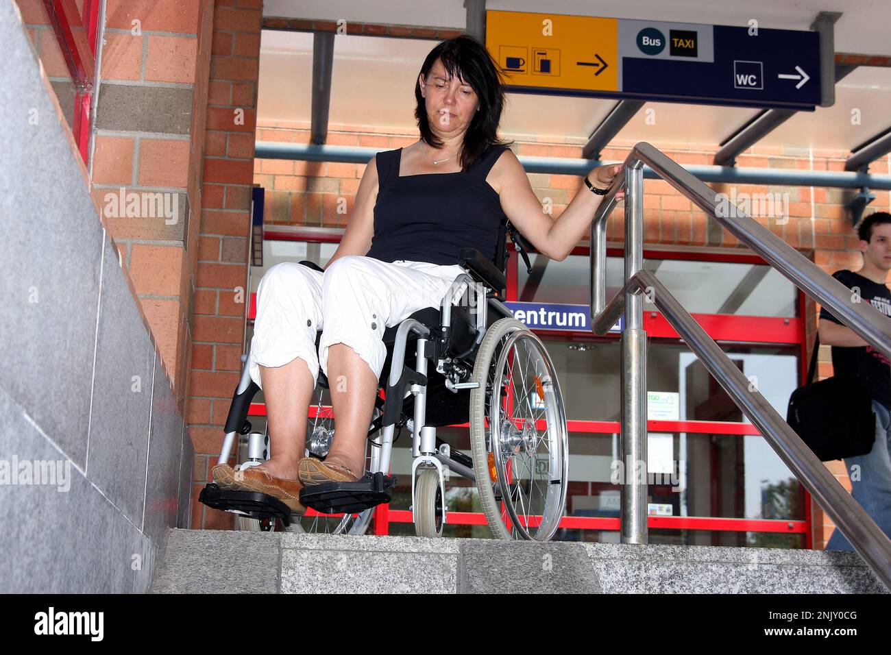 woman in a wheelchair at the with pram ramp at the train station, not ...
