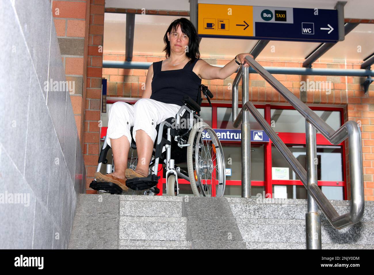 woman in a wheelchair at the with pram ramp at the train station, not ...