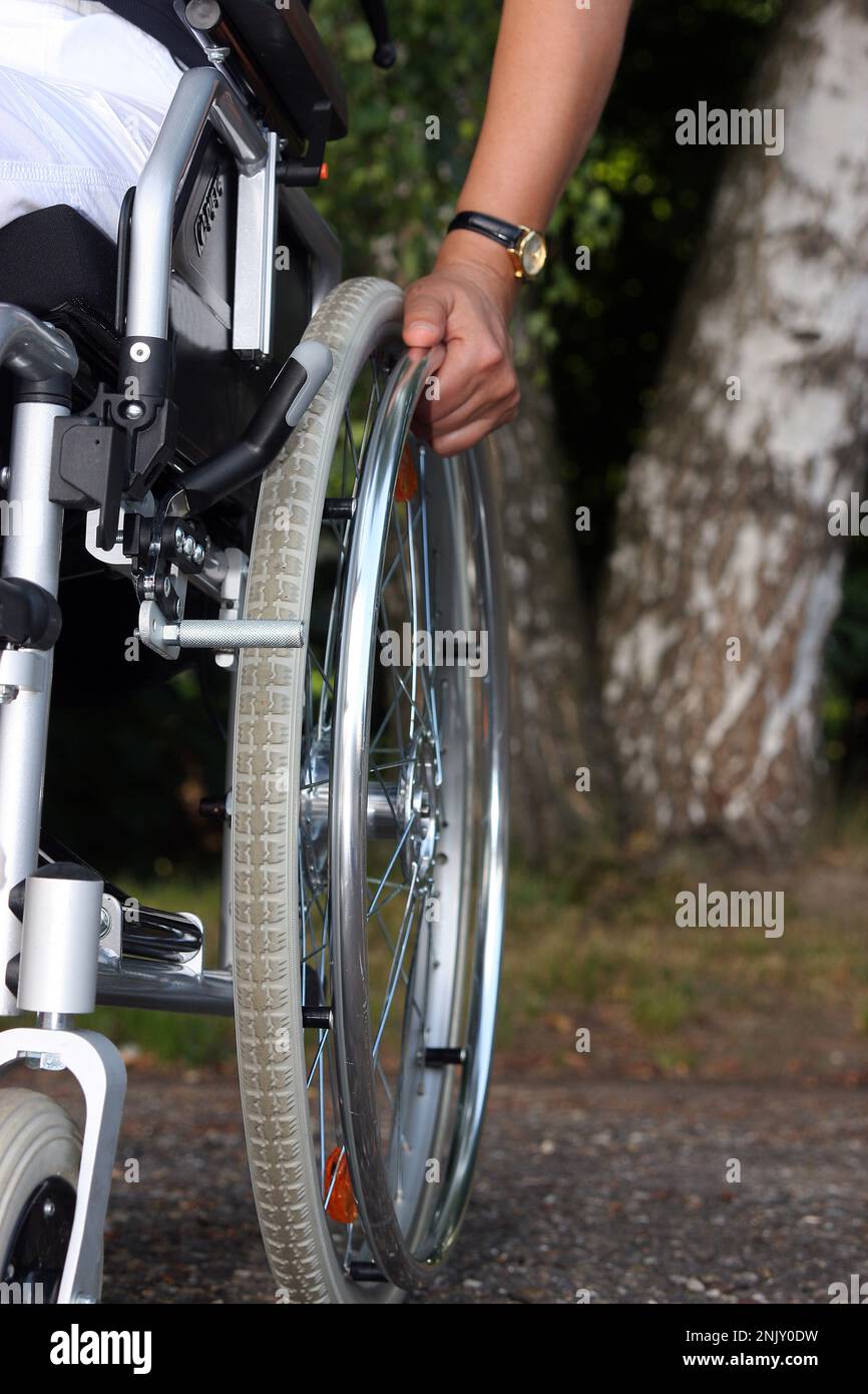woman in a wheelchair on a path, detail Stock Photo - Alamy