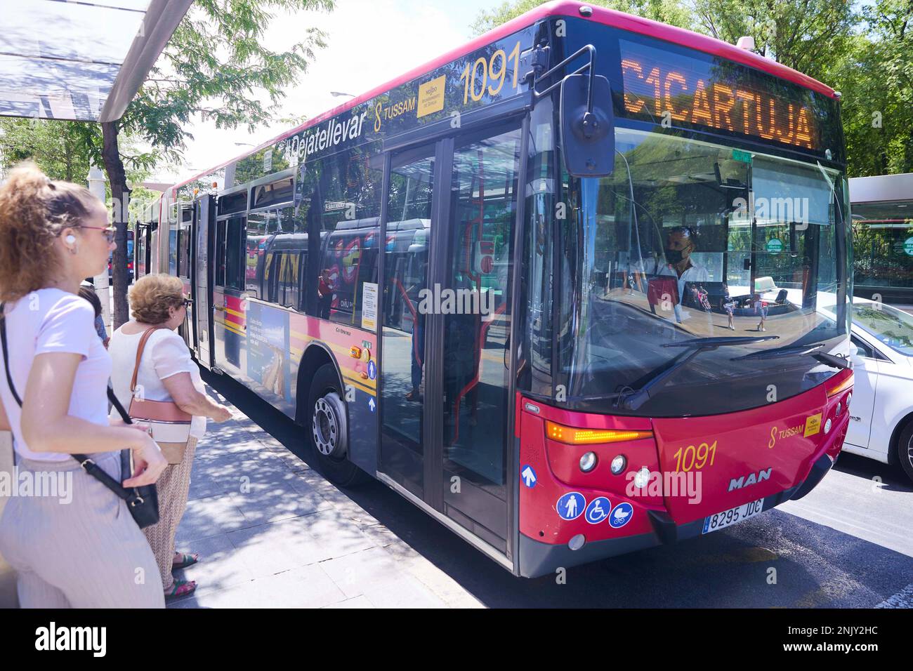 Two women wait for the doors of a Tussam bus to open on June 21, 2022 ...