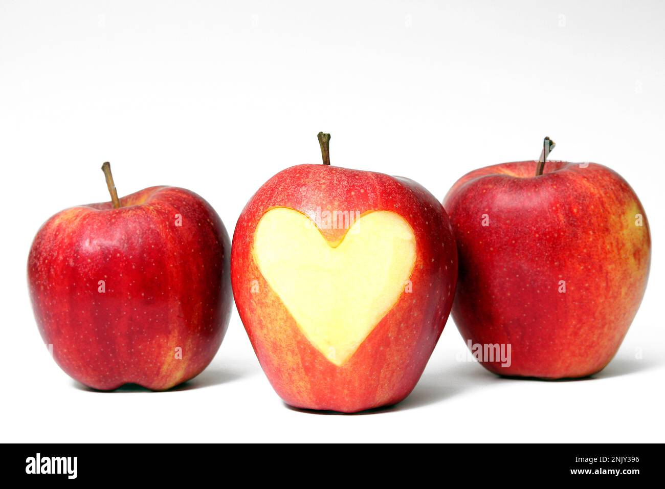 apple (Malus domestica), fresh red apples, one with engraved heart ...