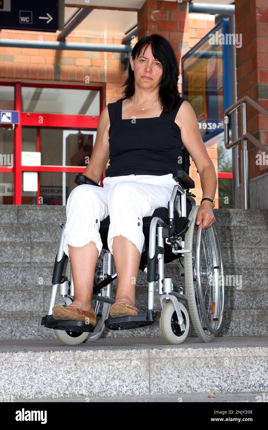 woman in a wheelchair on a staircase at the train station, not barrier ...