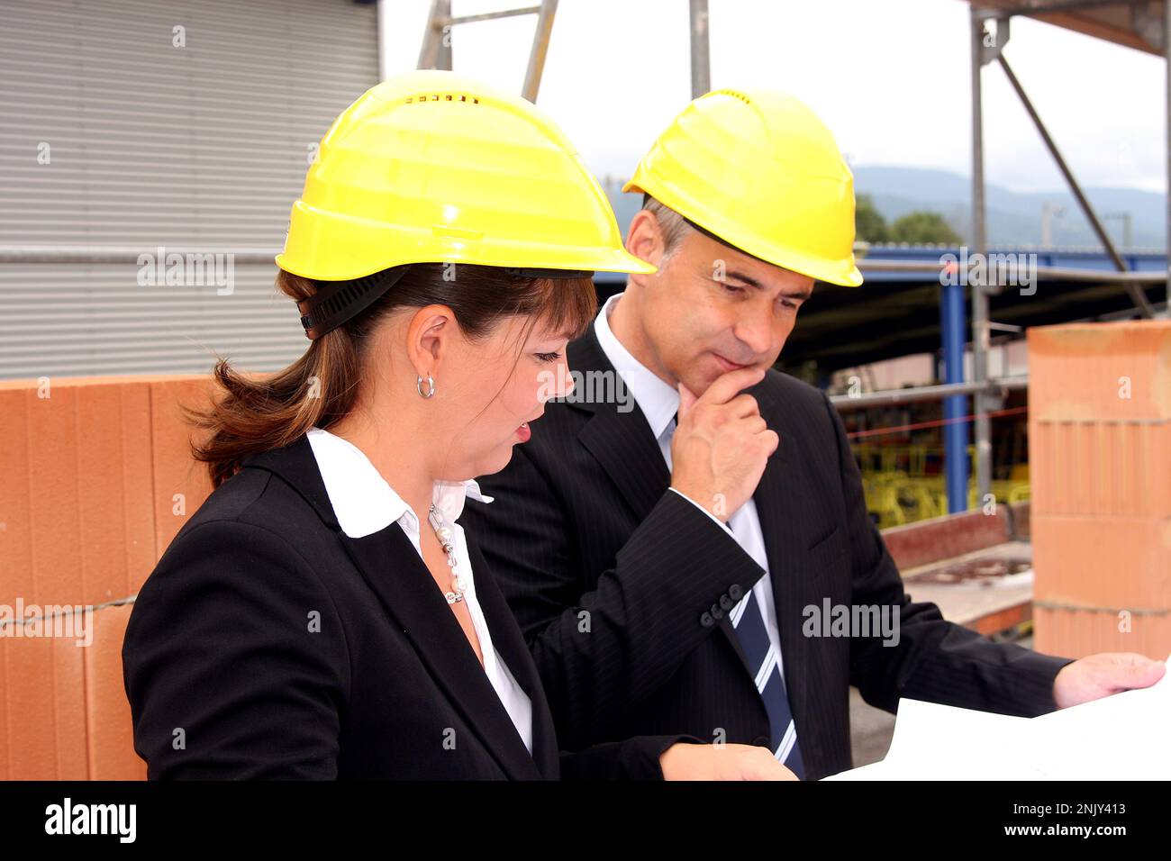Architects on the building site looking at the construction drawing ...