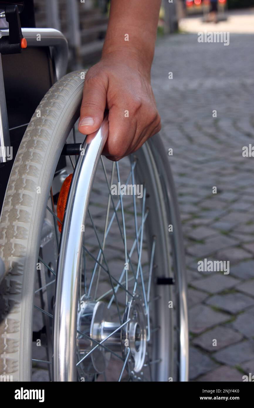 woman in a wheelchair on a pavement, detail Stock Photo - Alamy
