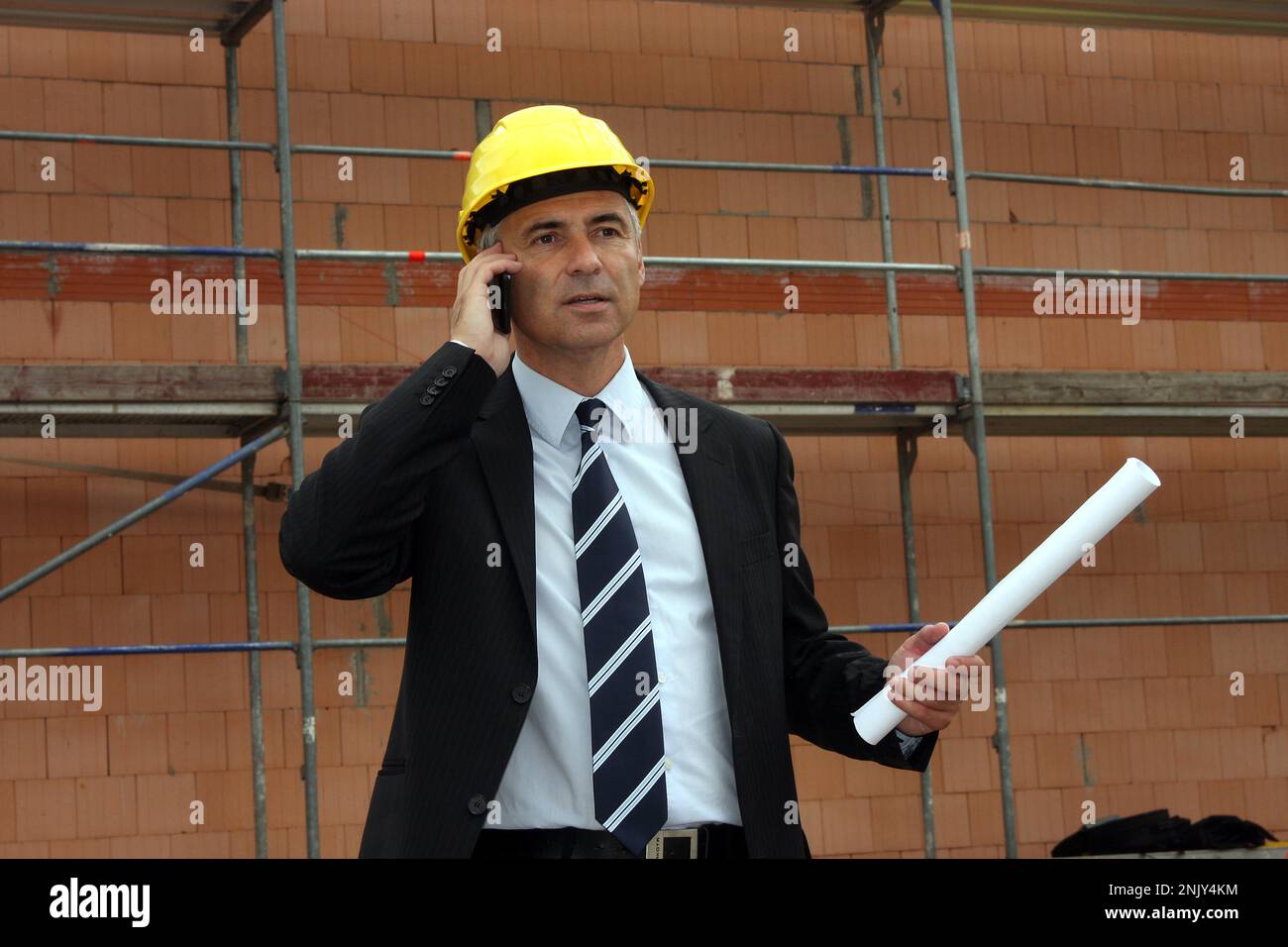 architect talking on the phone on the construction site, front view ...