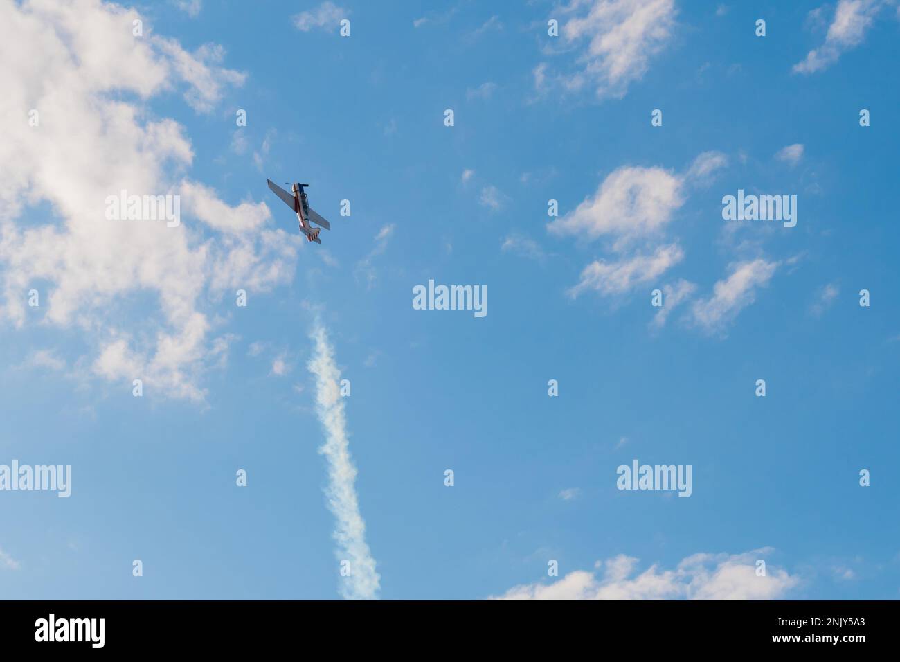 Light aircraft flying in blue sky and doing stunts Stock Photo - Alamy
